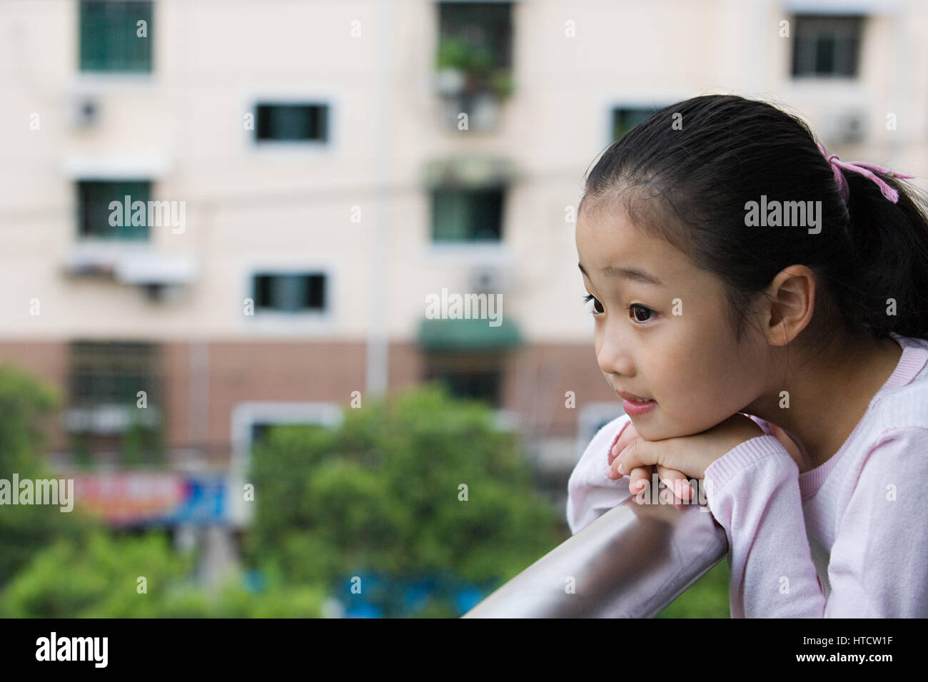 Girl leaning on a railing Stock Photo - Alamy