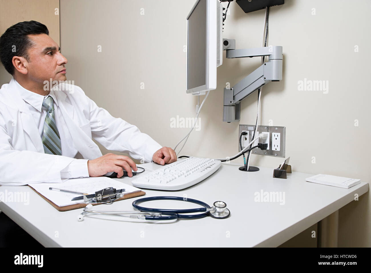 Doctor looking at computer screen Stock Photo - Alamy