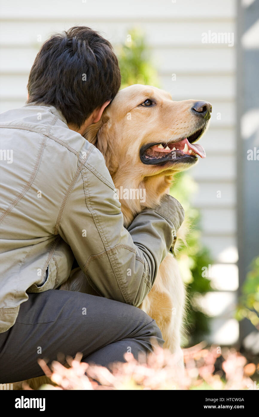 Teenage boy hugging pet dog Stock Photo - Alamy