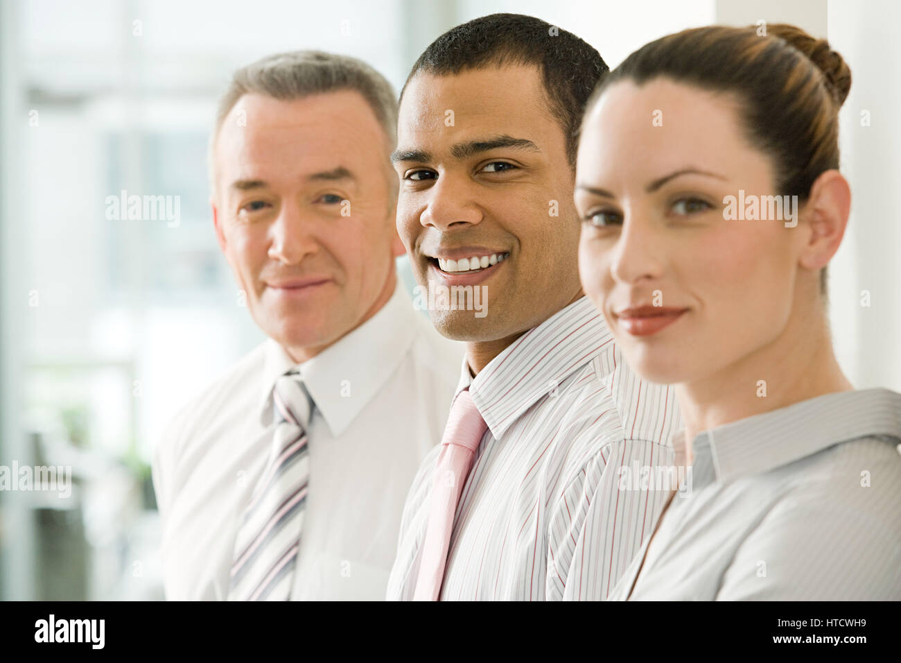 Three office workers in a row Stock Photo - Alamy