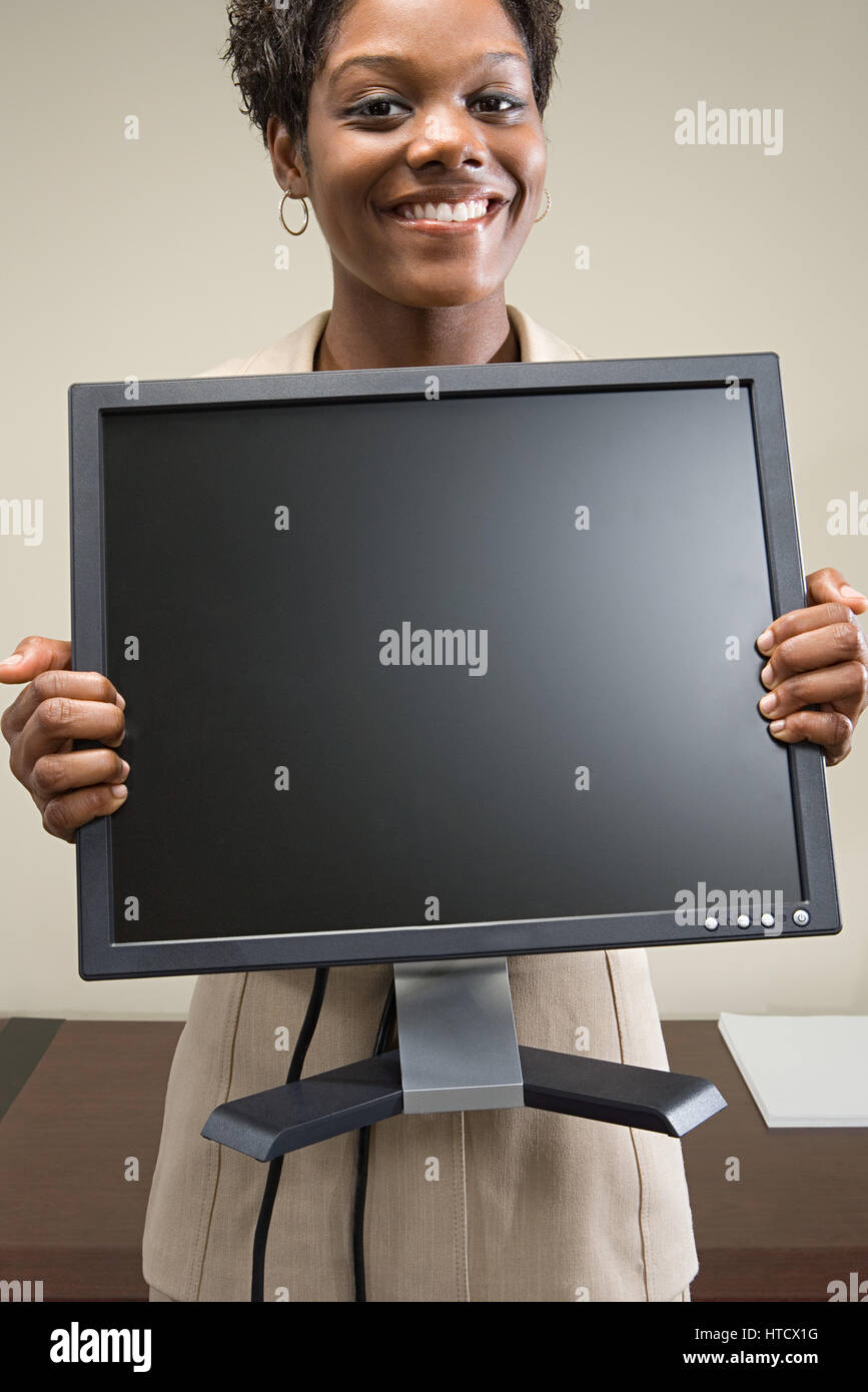 Woman holding computer monitor Stock Photo - Alamy