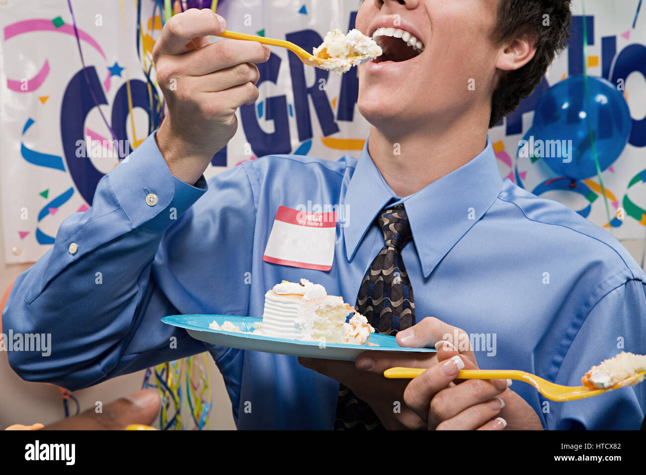 Businessman eating party cake Stock Photo - Alamy
