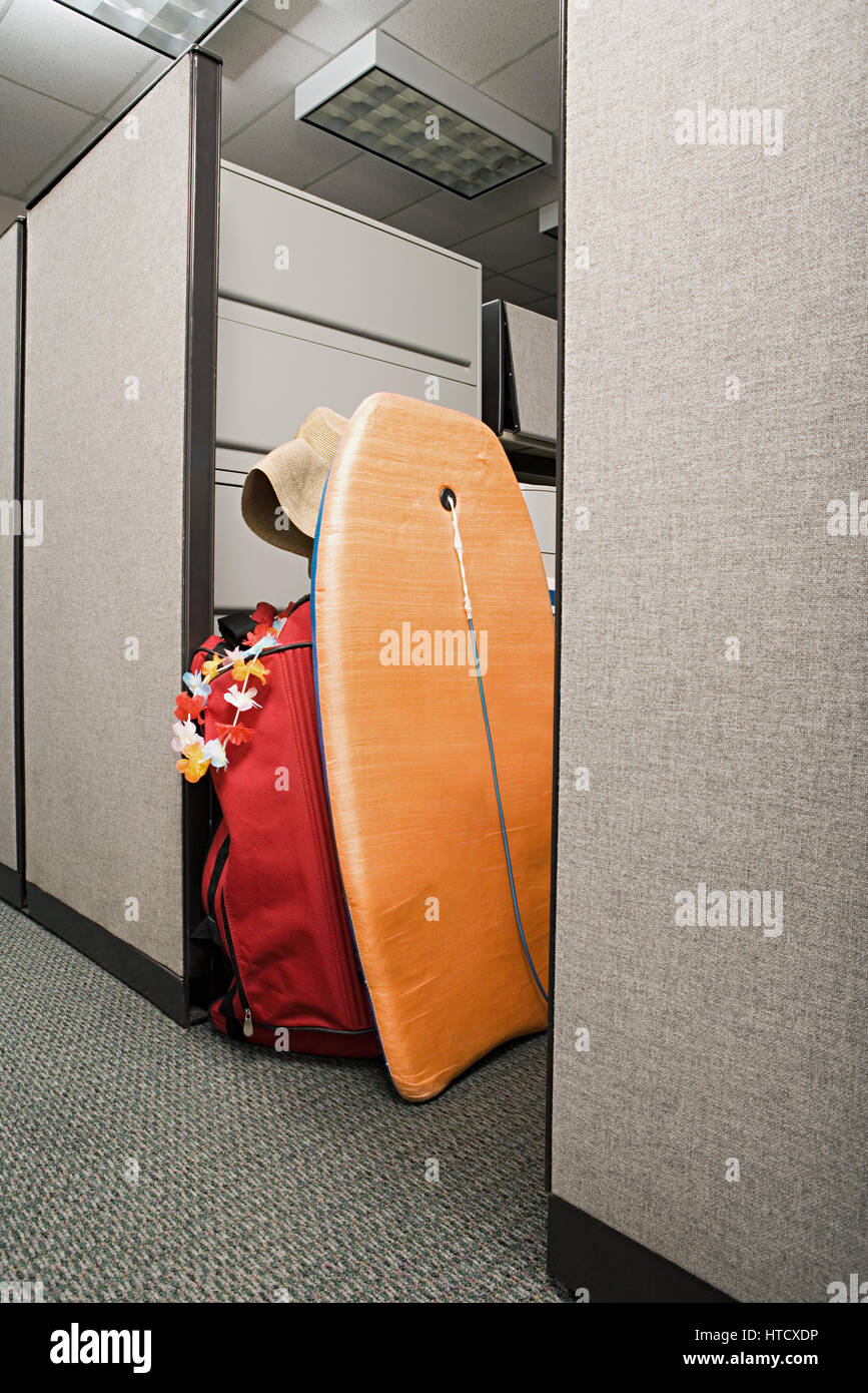 Suitcase and body board in office cubicle Stock Photo - Alamy