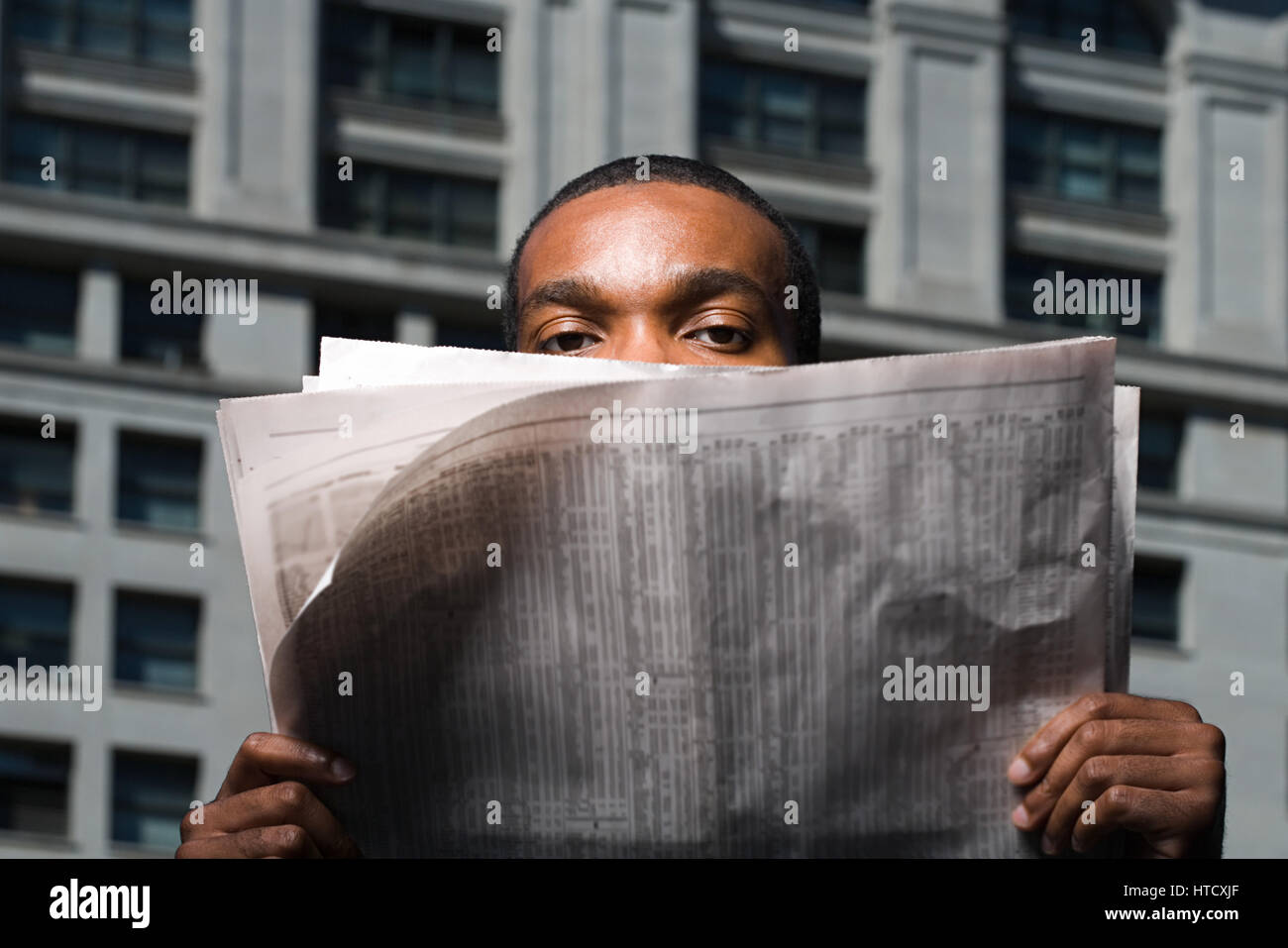 Man looking over newspaper Stock Photo - Alamy