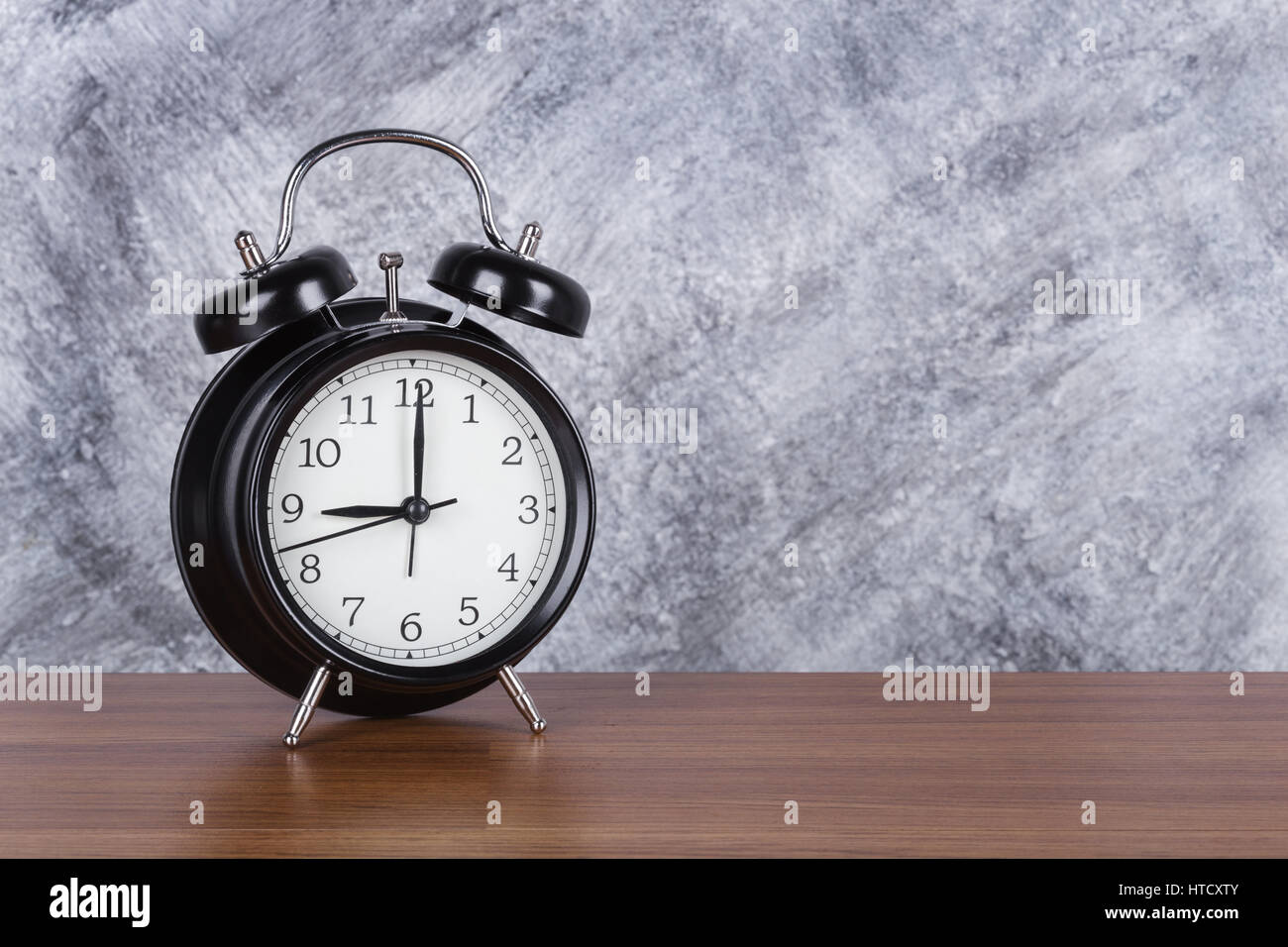 9 o'clock vintage clock on wood table and concrete wall background ...