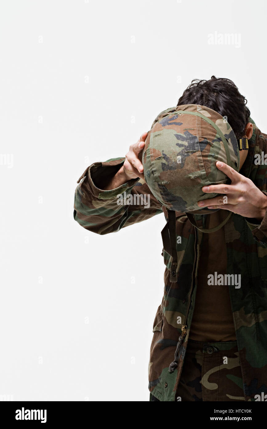 Soldier putting on helmet Stock Photo - Alamy