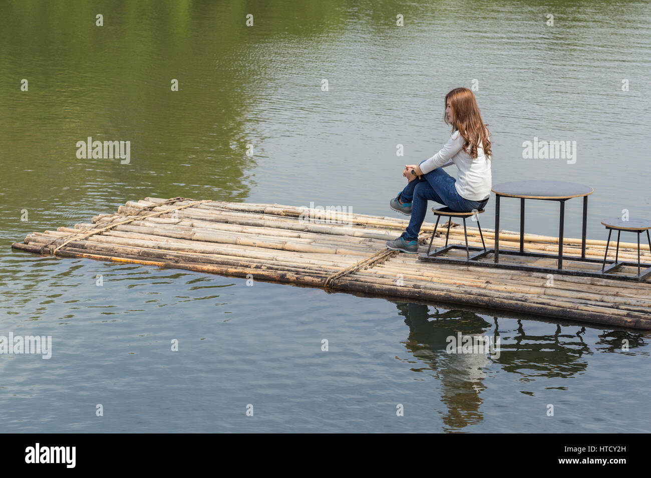 Woman sitting on a bamboo raft in the river Stock Photo - Alamy