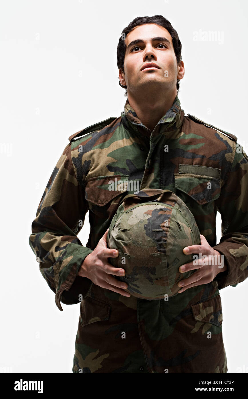 Young male soldier holding helmet Stock Photo - Alamy