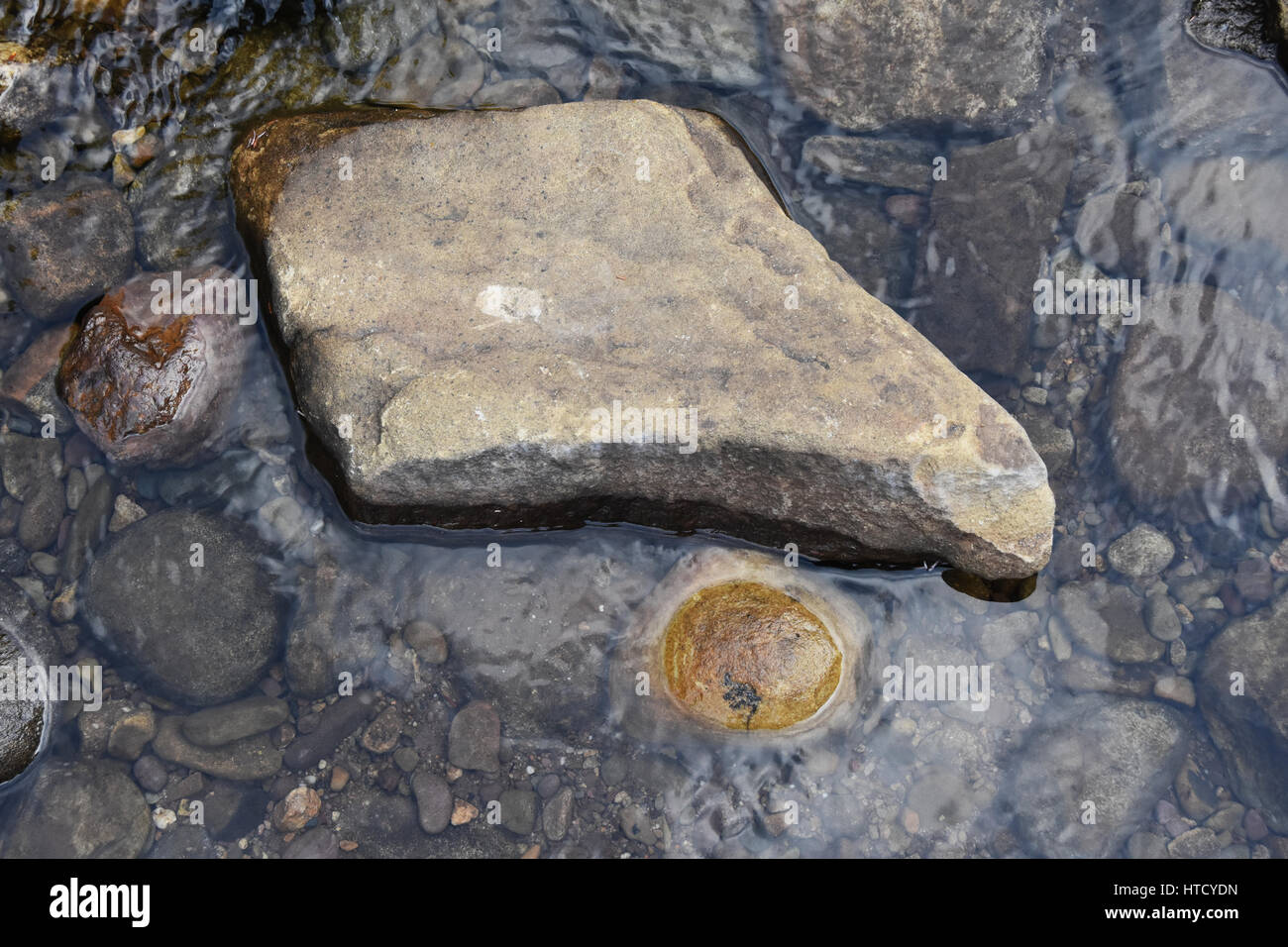 River rock surrounded by water ripples Stock Photo - Alamy