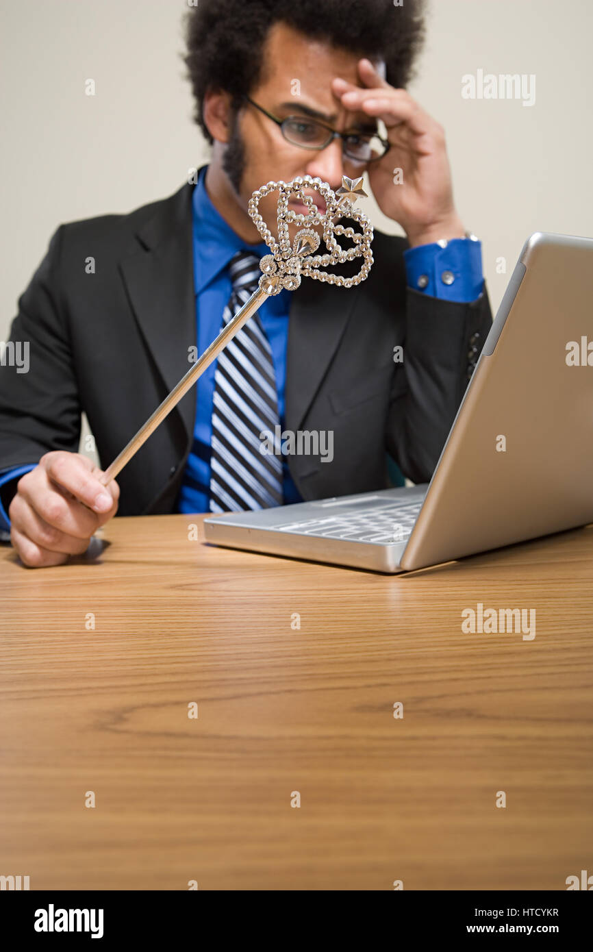 Businessman holding wand Stock Photo - Alamy