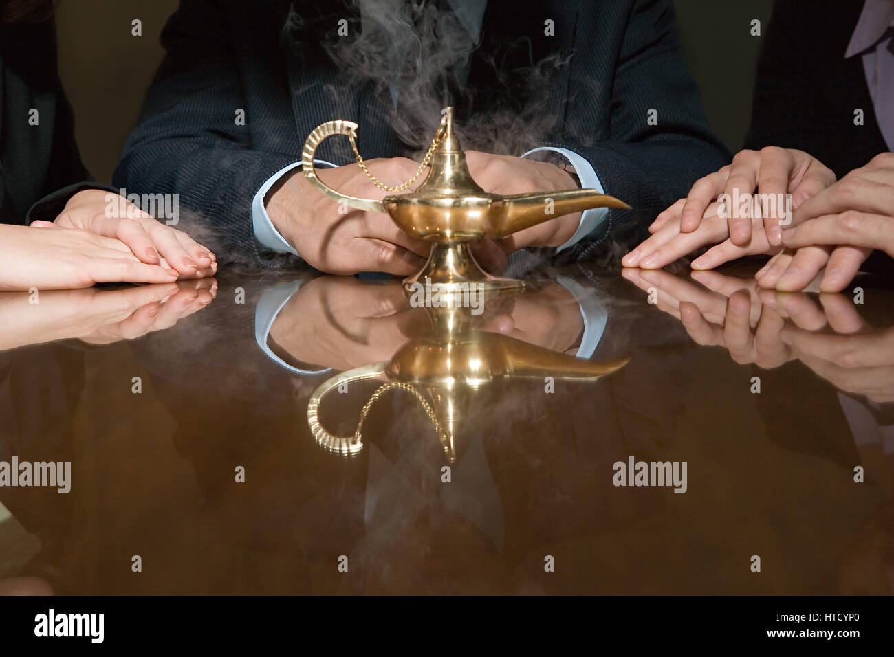 Colleagues around a smoking genie lamp Stock Photo - Alamy
