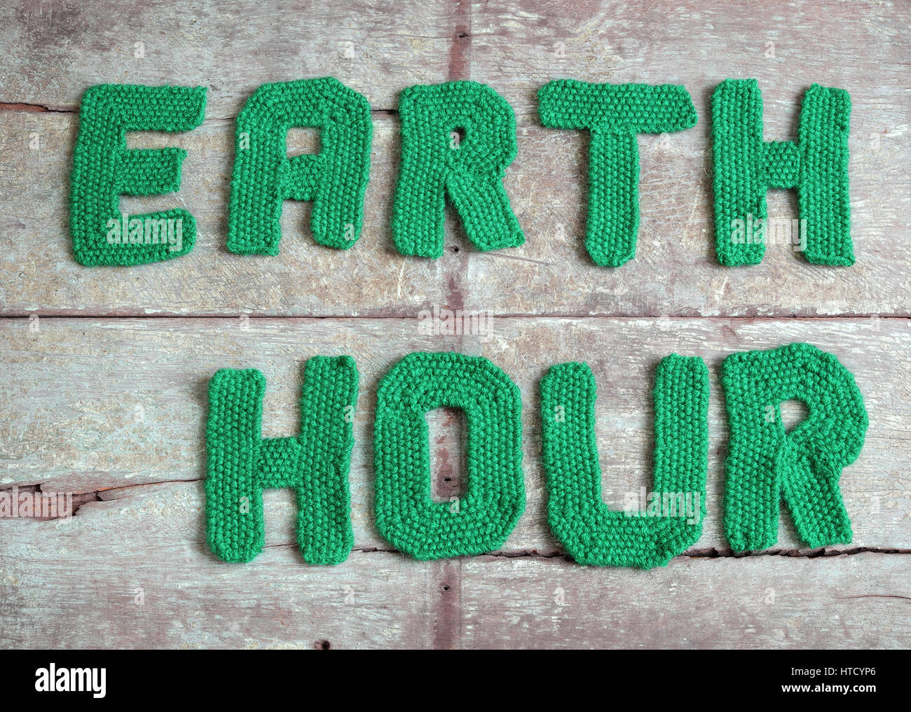 Earth hour letter in green yarn on wood background, a symbol for save ...