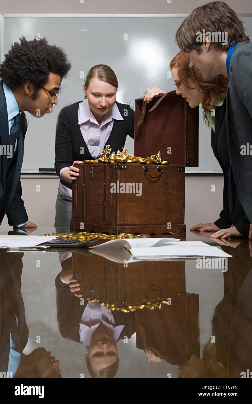 Colleagues around a treasure chest Stock Photo - Alamy