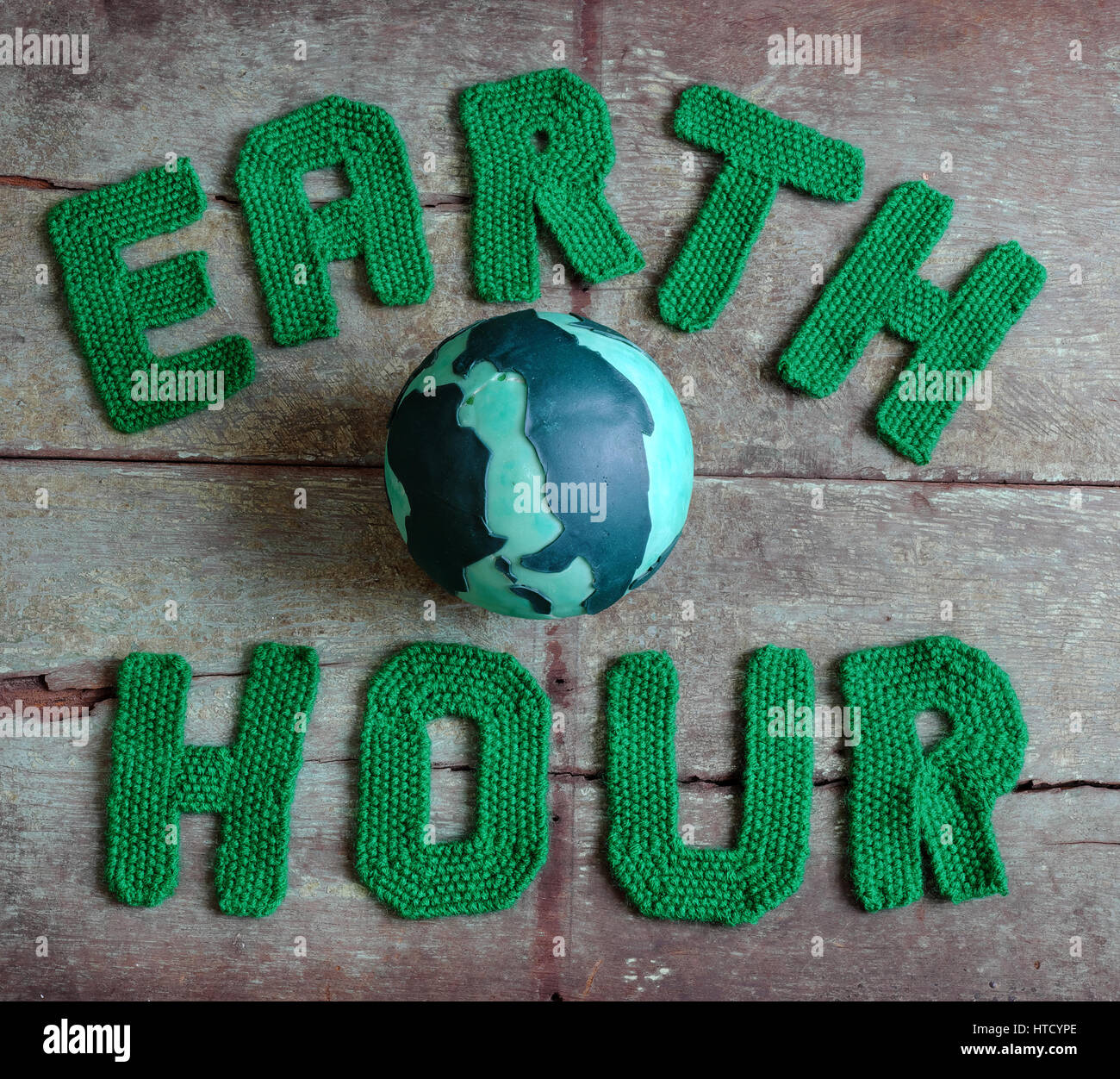 Earth hour letter in green yarn on wood background, a symbol for save ...