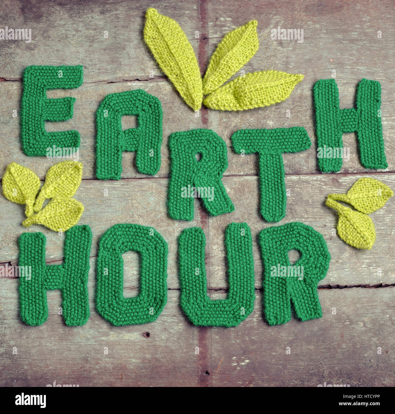 Earth hour letter in green yarn on wood background, a symbol for save ...