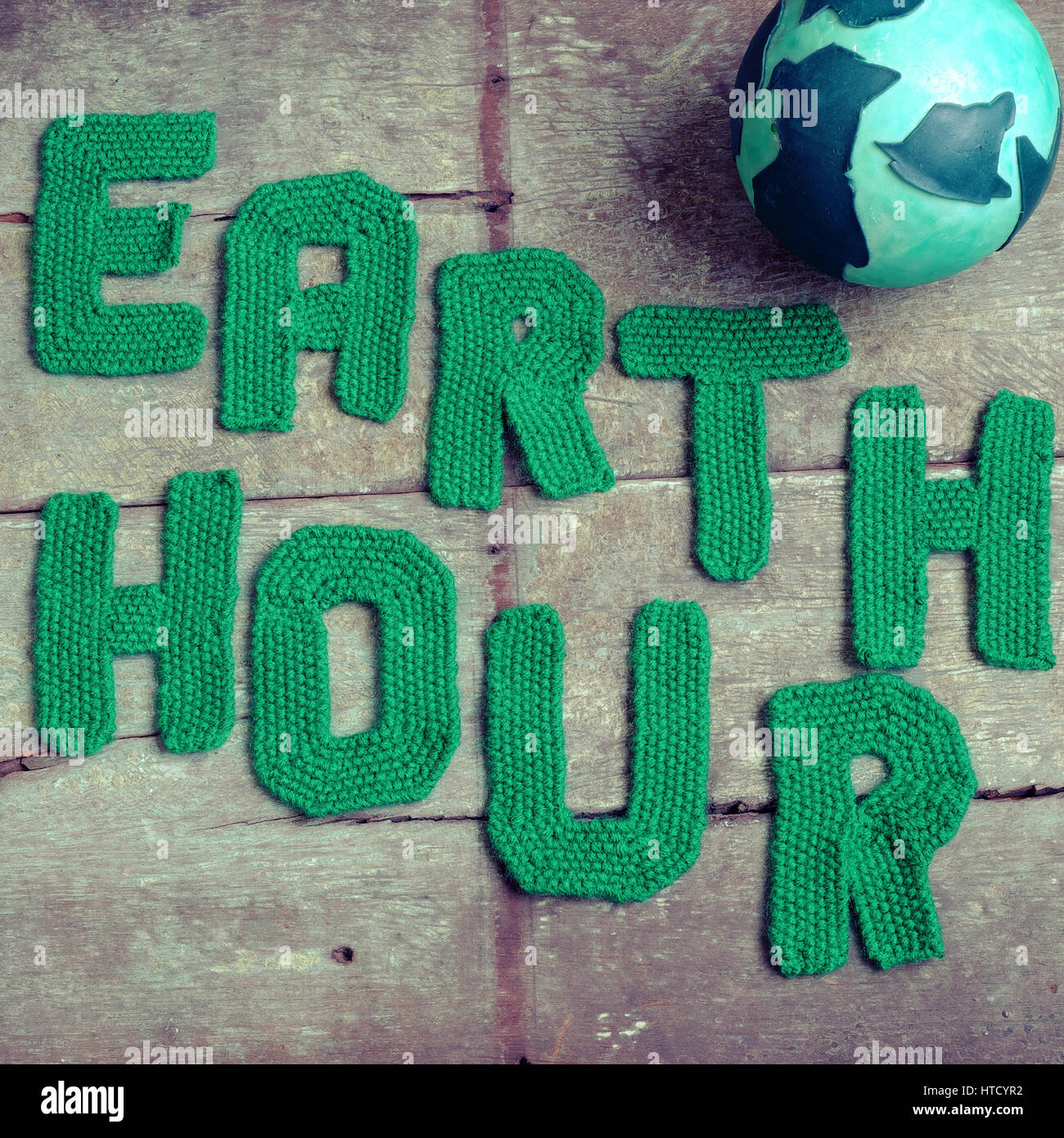 Earth hour letter in green yarn on wood background, a symbol for save ...