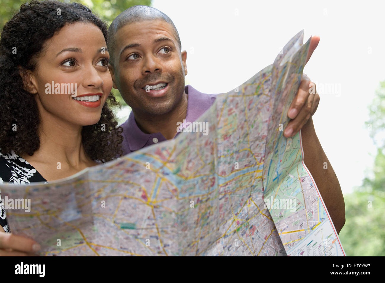 Couple with a map Stock Photo - Alamy