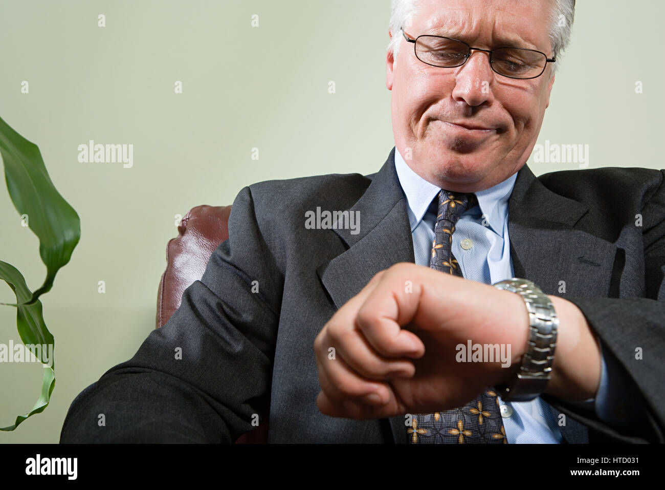 Man looking anxiously at watch Stock Photo - Alamy