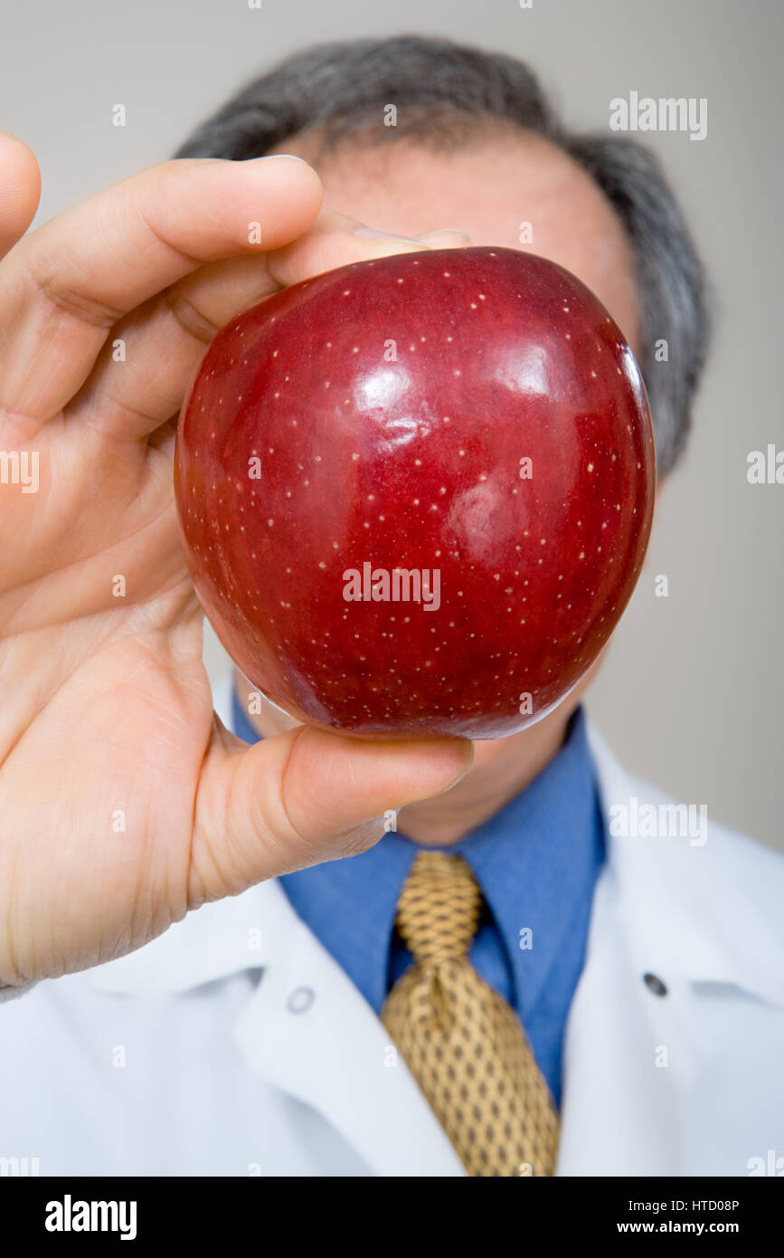 Dentist holding apple Stock Photo - Alamy
