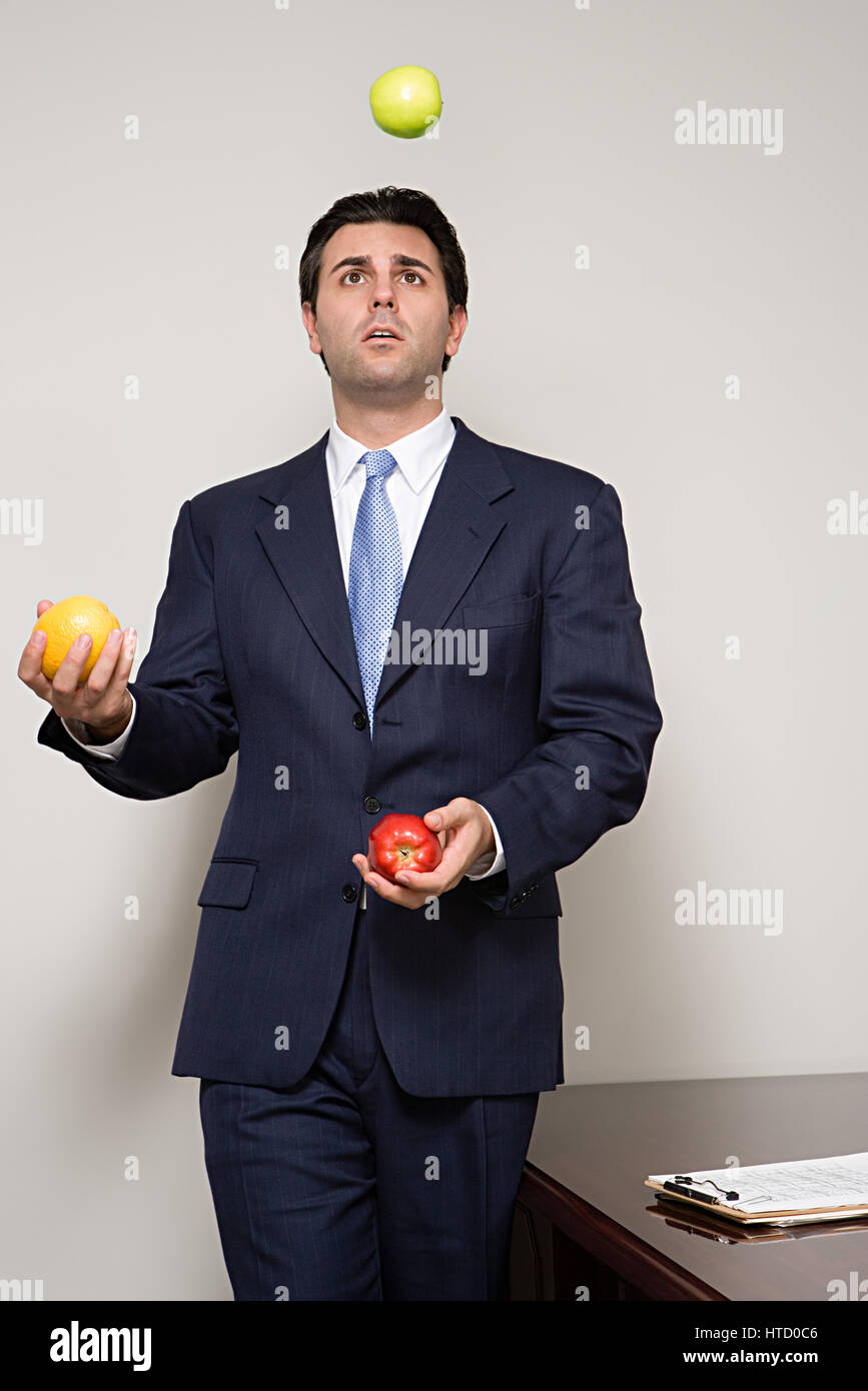 Businessman juggling fruit Stock Photo - Alamy