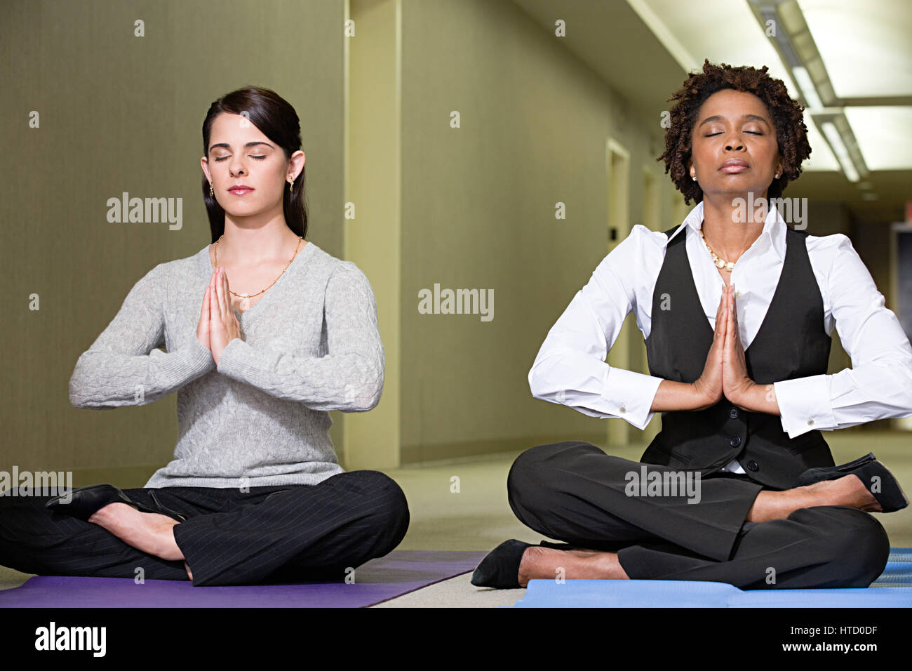 Women meditating in corridor Stock Photo - Alamy