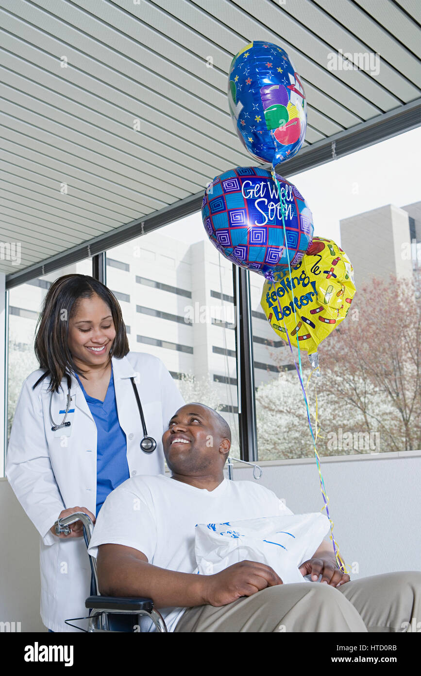 Doctor pushing patient in a wheelchair Stock Photo - Alamy
