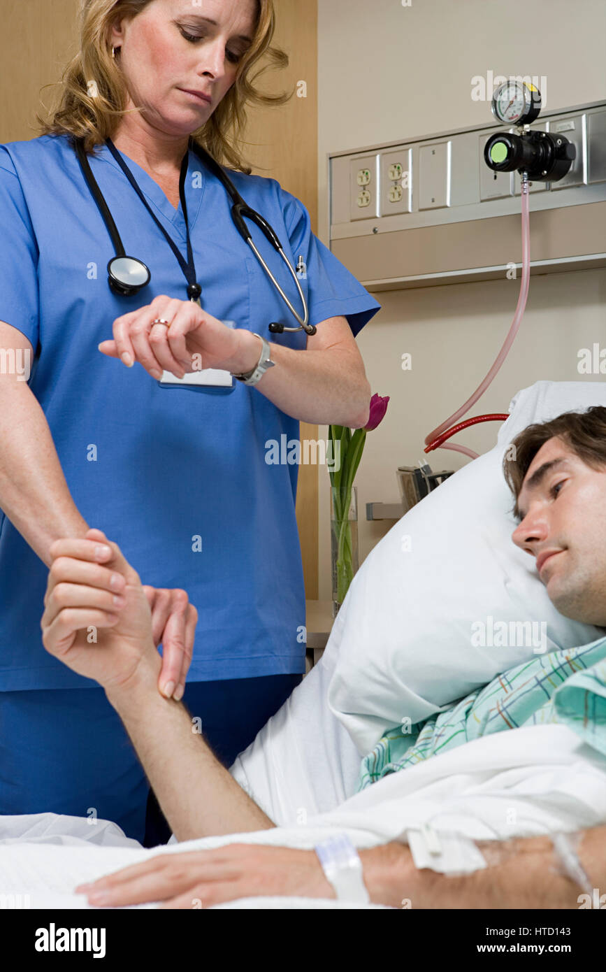 Doctor checking patients pulse Stock Photo - Alamy