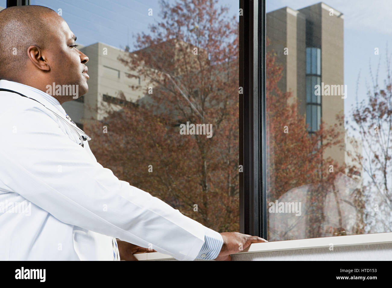 Doctor looking out of window Stock Photo - Alamy