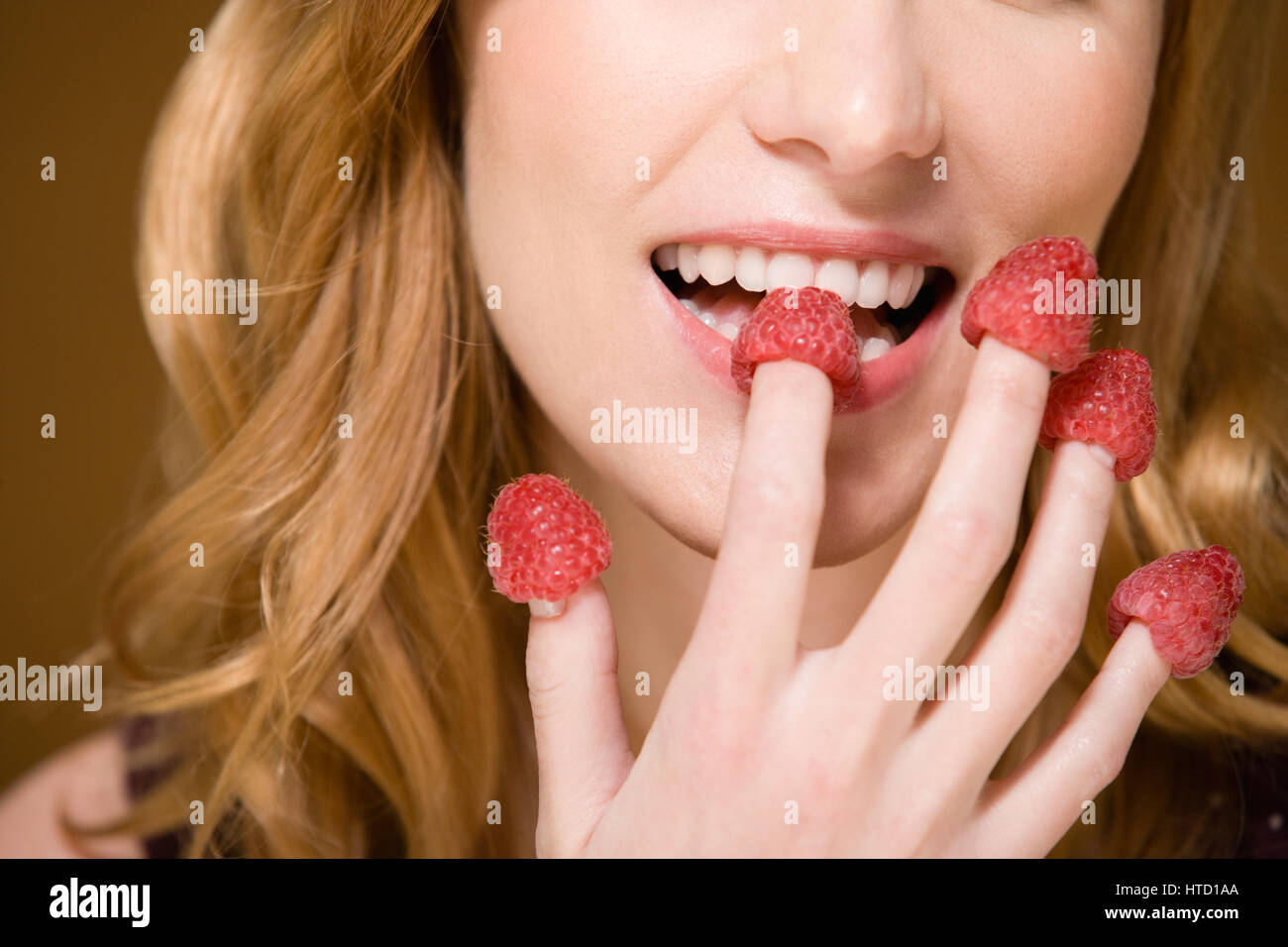Woman eating raspberries Stock Photo - Alamy