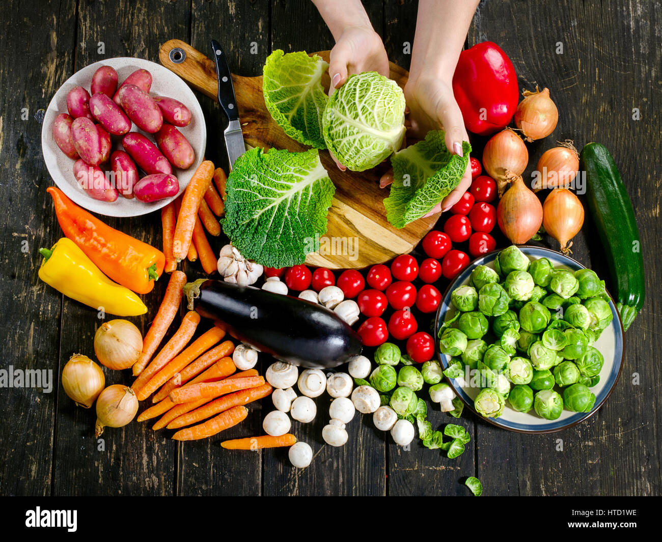 Woman hands cooking vegetables on dark wooden board. Healthy eating and ...