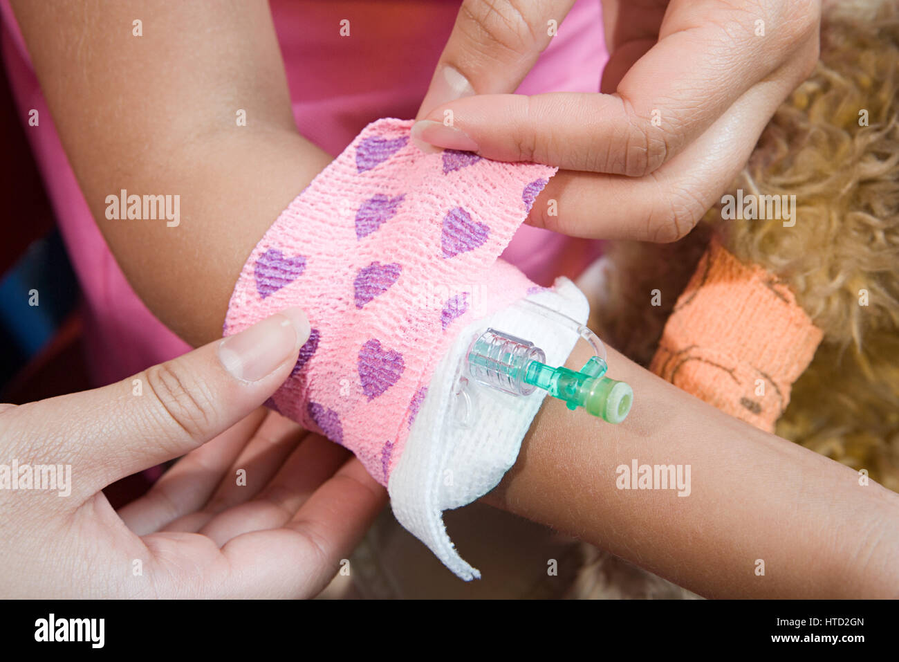 Girl having bandage put around catheter Stock Photo - Alamy