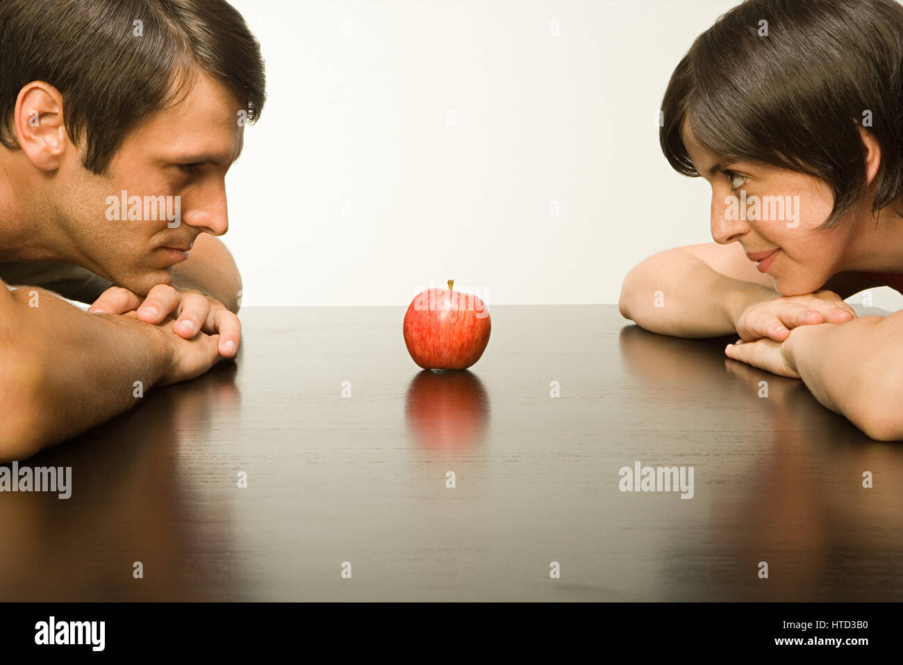 Apple on table between couple Stock Photo - Alamy