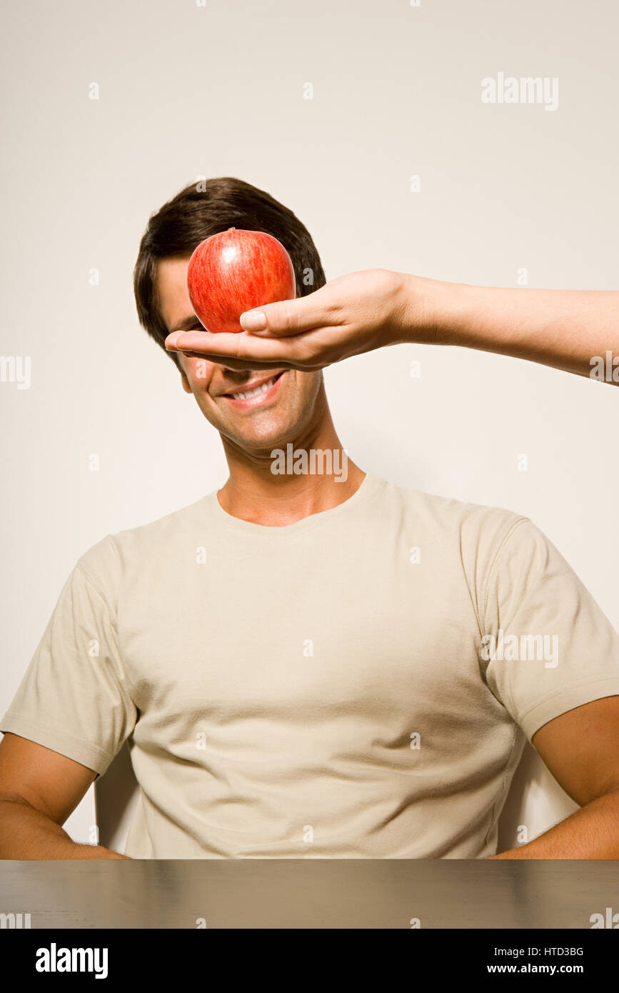 Man with apple in front of his face Stock Photo - Alamy