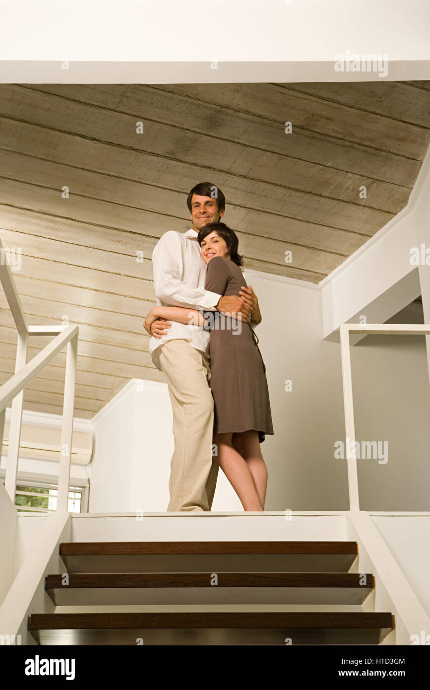 Couple hugging at top of stairs Stock Photo - Alamy