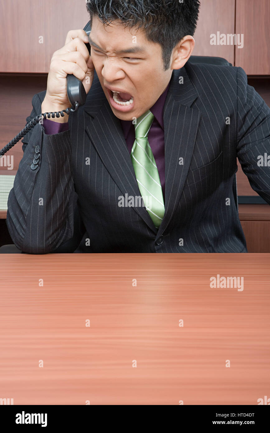 Businessman shouting down phone Stock Photo - Alamy