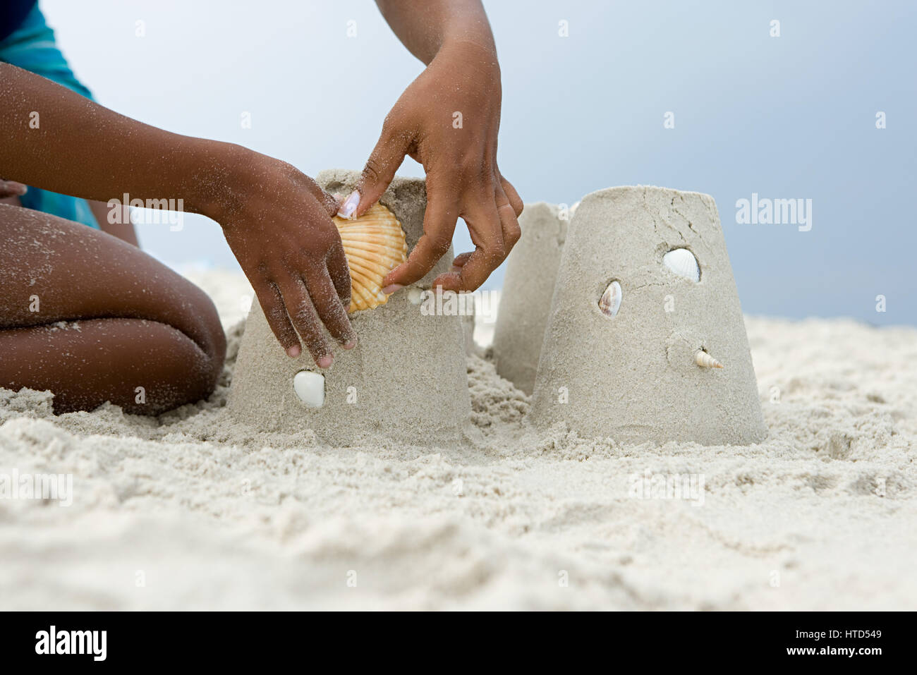 Mother and child putting a shell on a sandcastle Stock Photo - Alamy