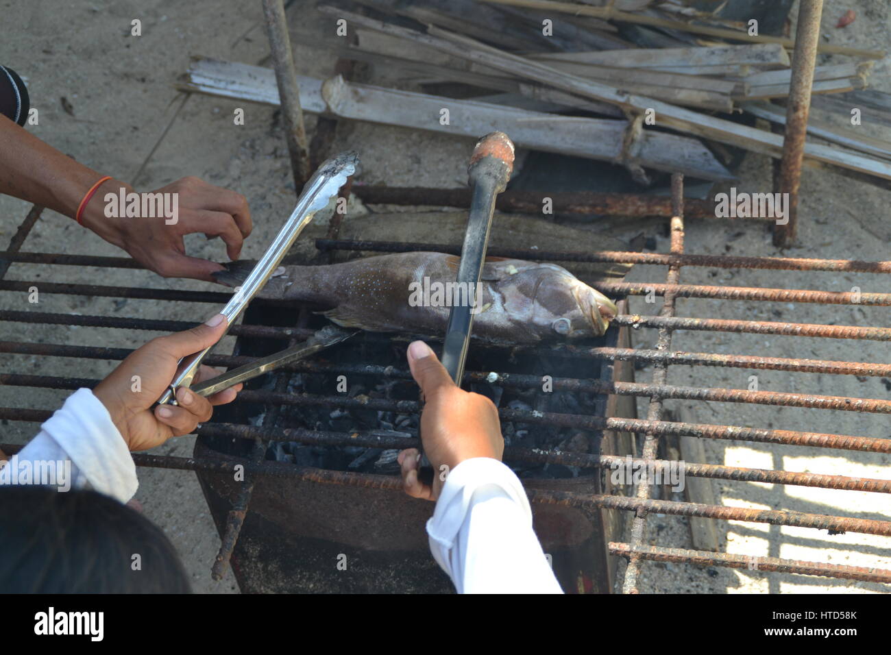 Primitive grilling tasty fish on an island Honda Bay near Palawan on ...