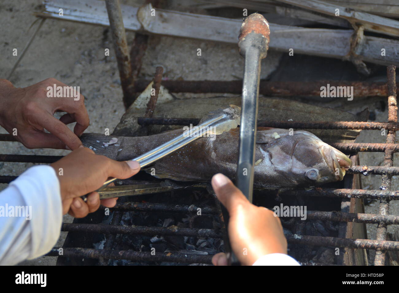 Primitive grilling tasty fish on an island Honda Bay near Palawan on ...