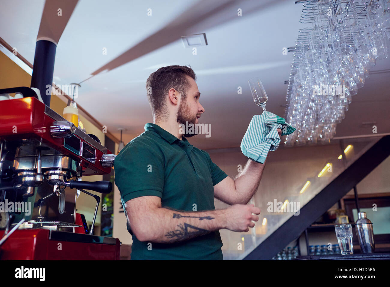 Bartender, barista working wipes the glass with cloth in a restaurant ...