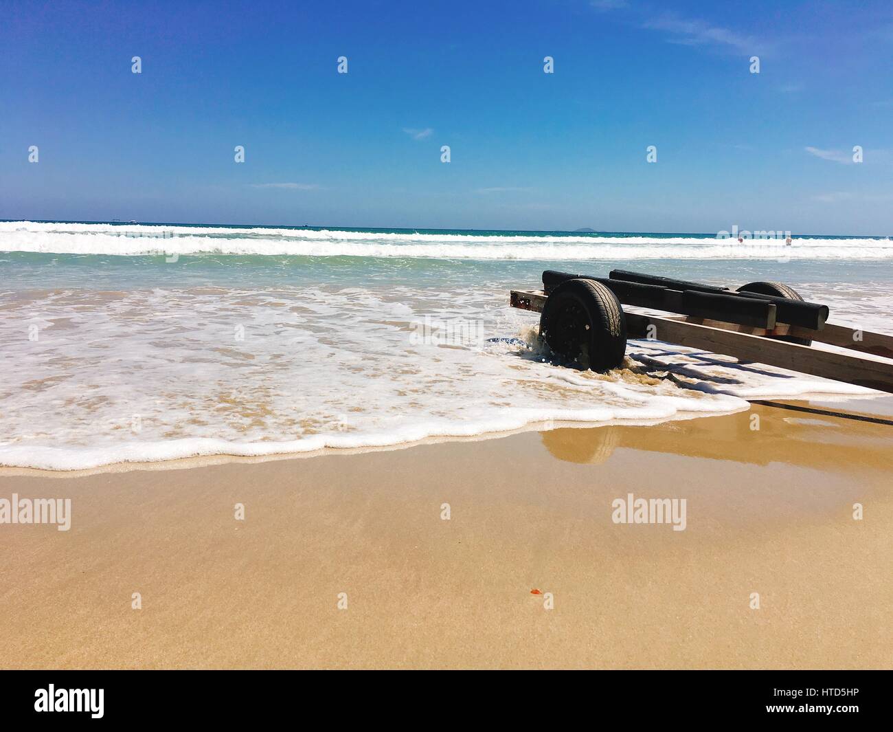 The wheelbarrow on the beach with sea wave foam Stock Photo - Alamy