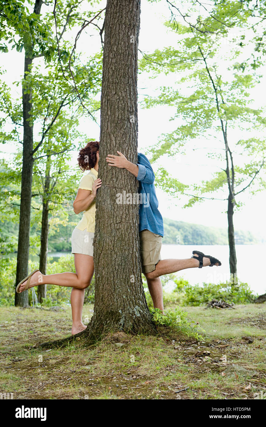 Couple kissing behind a tree Stock Photo - Alamy
