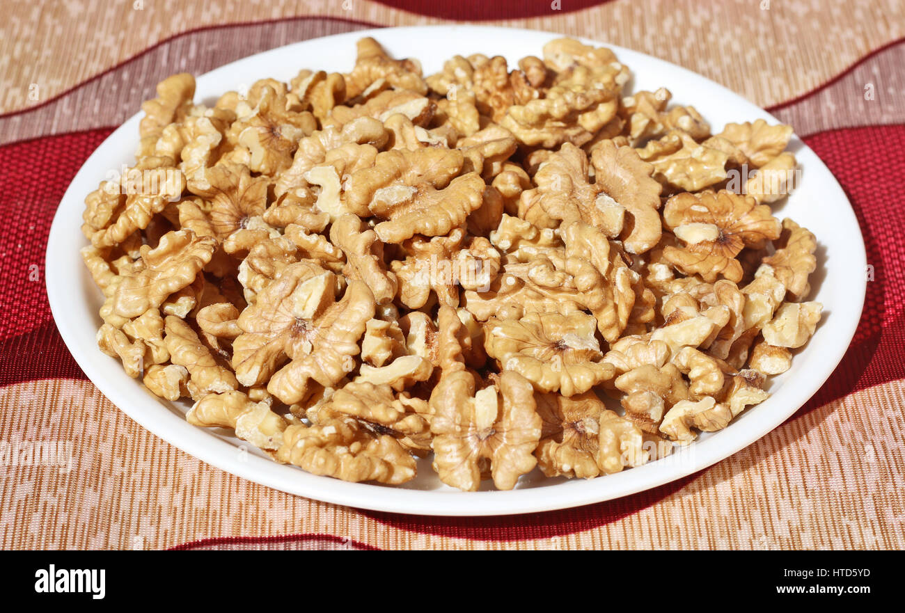 Raw walnut isolated on the red-grey background in white plate Stock ...