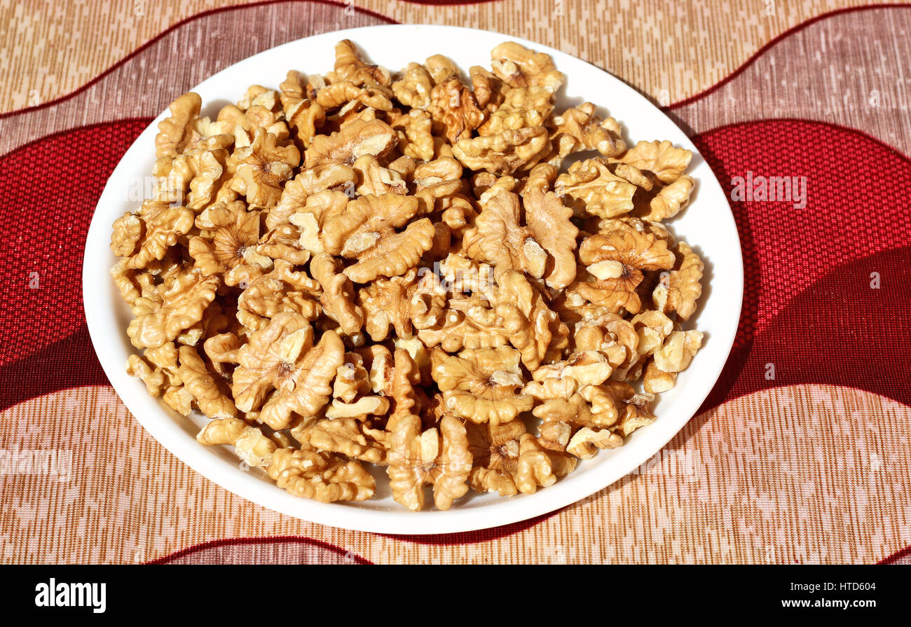 Raw walnut isolated on the red-grey background in white plate Stock ...