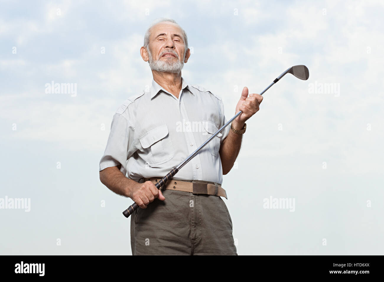 Man holding a golf club Stock Photo - Alamy