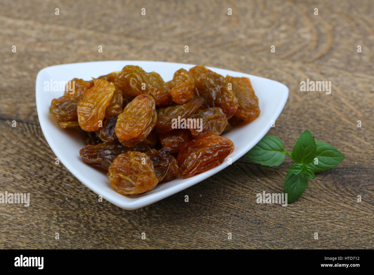 Sweet raisins in the bowl with mint leaves Stock Photo - Alamy