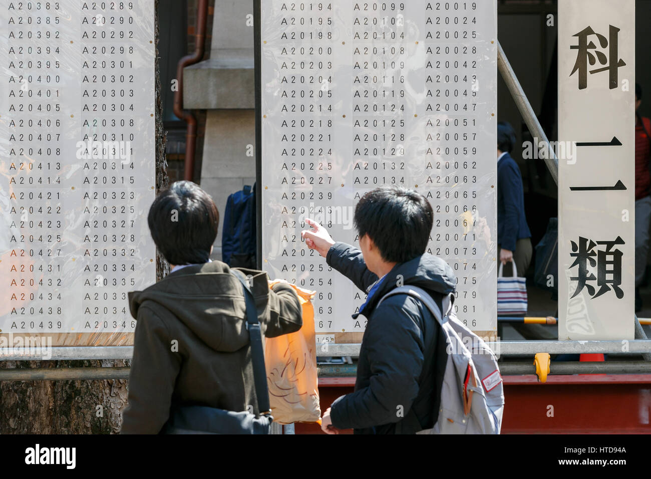 Japanese students look for their exam numbers on the list at the ...