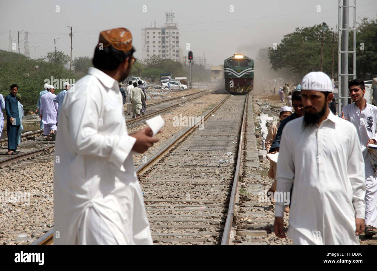 People passing through railway track on another hand train is just ...