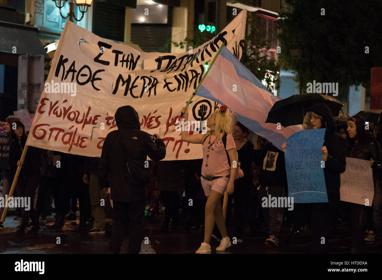 Women and men march in the streets of Athens shouting slogans and ...