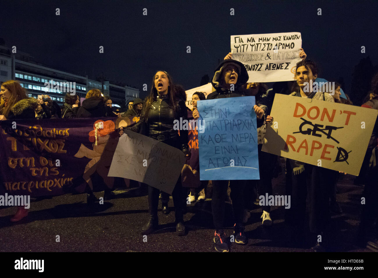 Women and men march in the streets of Athens shouting slogans and ...