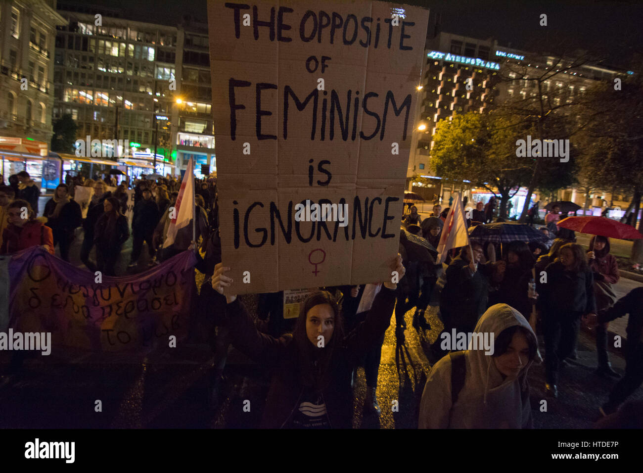 Women and men march in the streets of Athens shouting slogans and ...